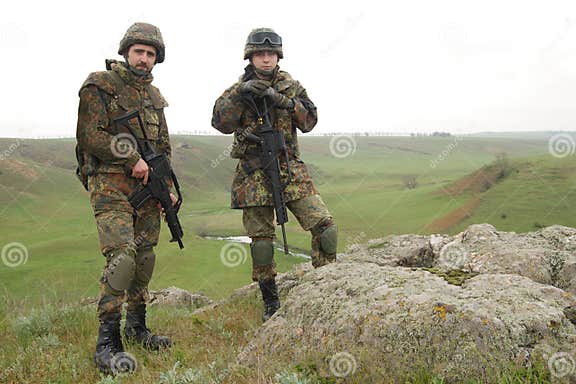 Two soldiers on the rock stock photo. Image of machine - 19472788
