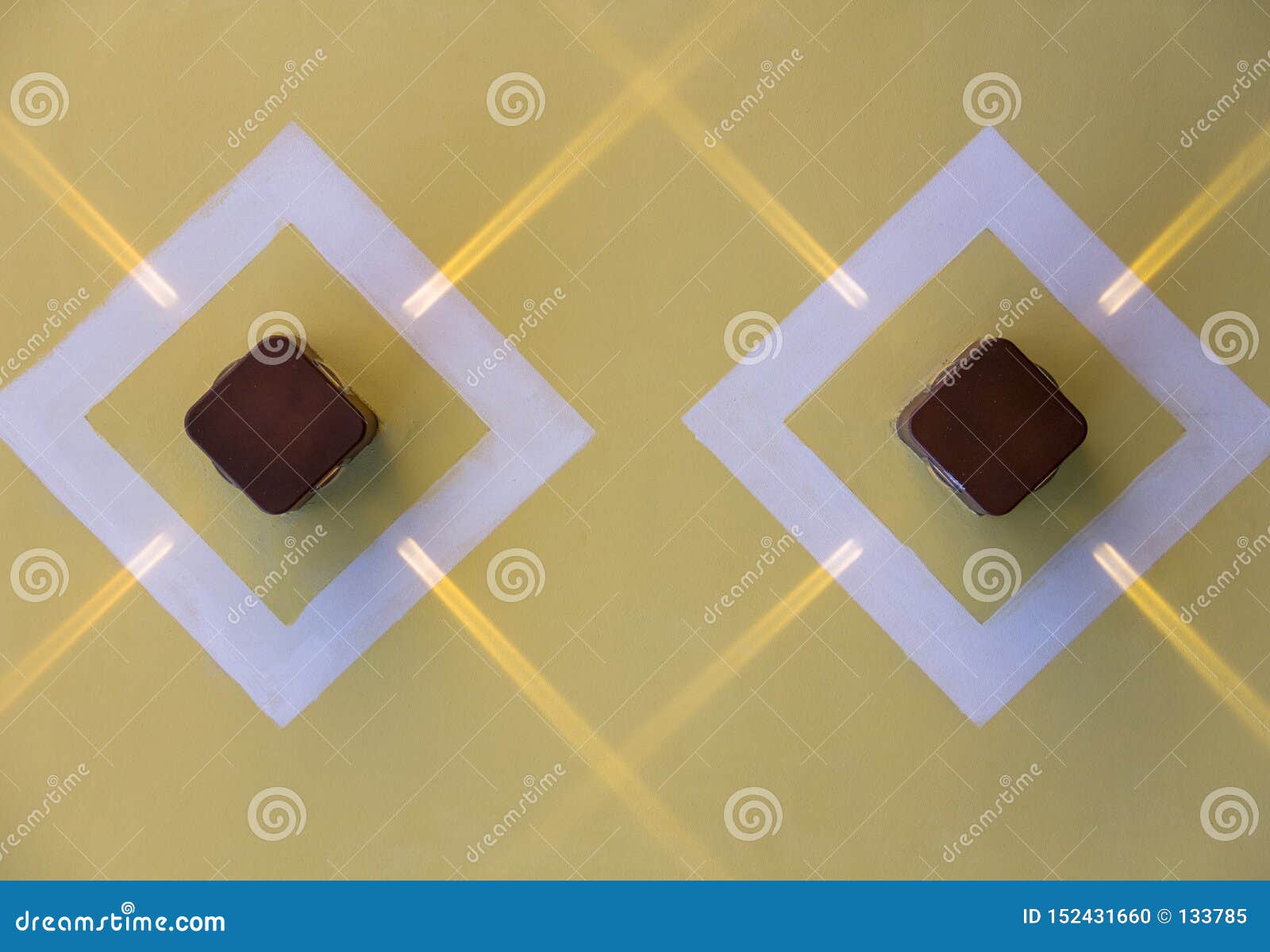 Two Square Brown Lamps with Rays of Light on a Yellow Wall in White ...