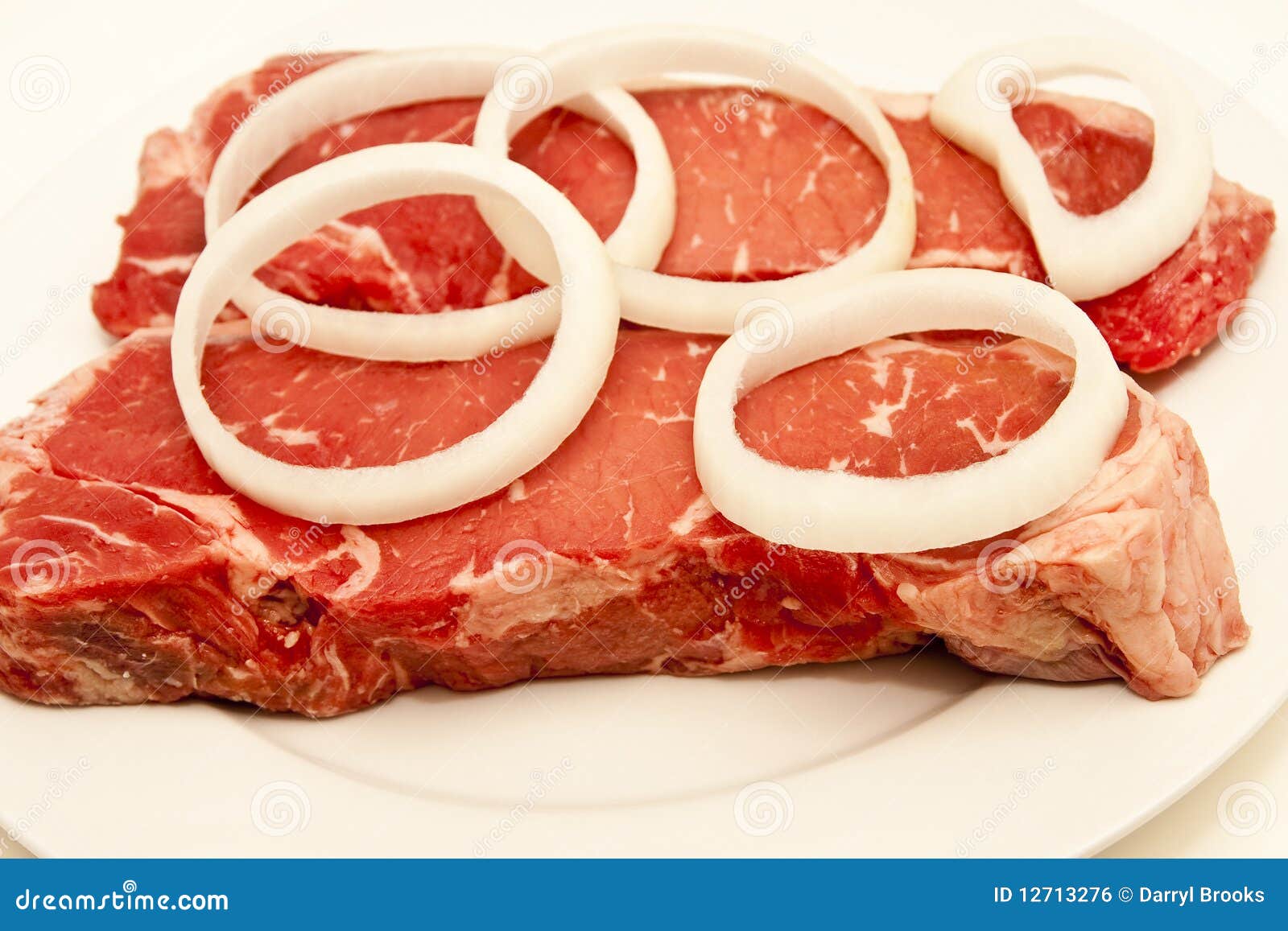 Two Strip Steaks on White Plate with Onion Slices Stock Photo - Image ...