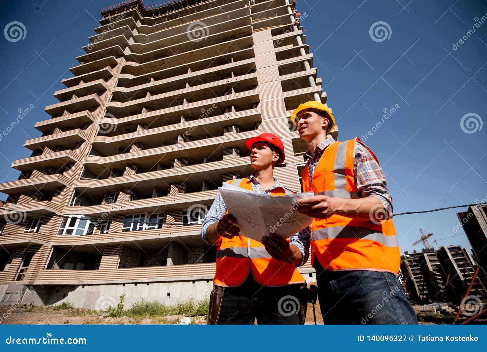 Two Structural Engineers Dressed in Shirts, Orange Work Vests and ...