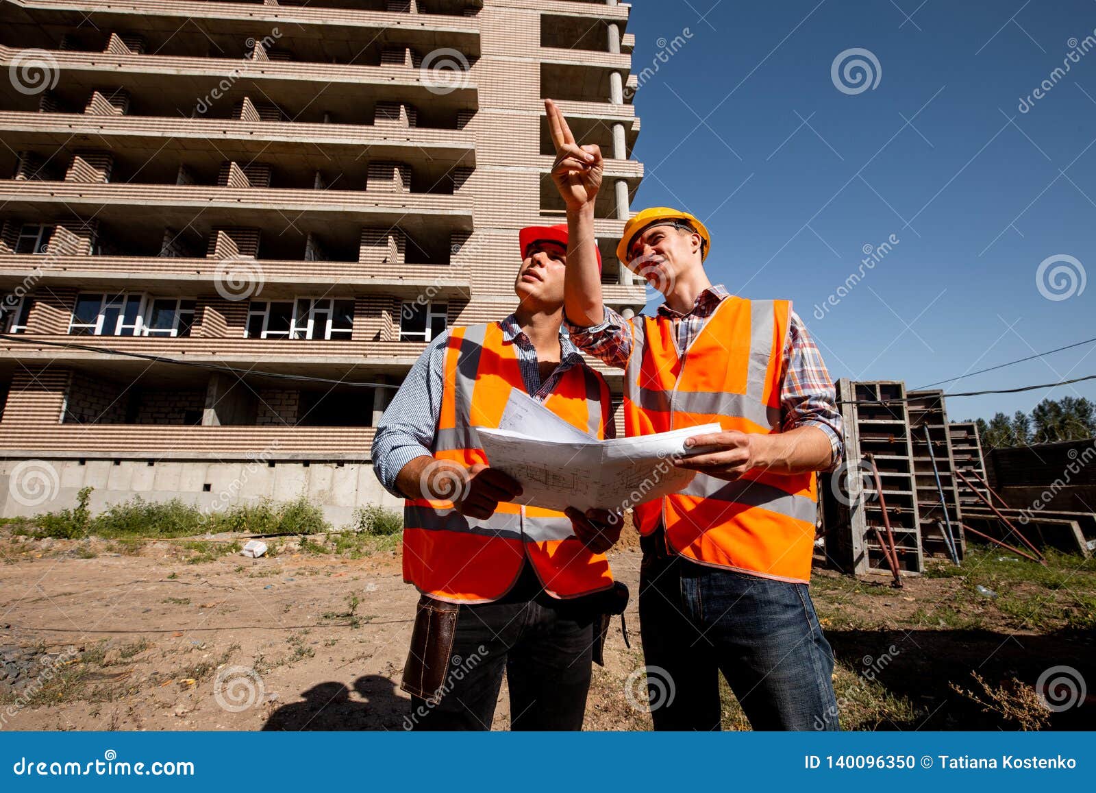 Two Structural Engineers Dressed in Shirts, Orange Work Vests and ...