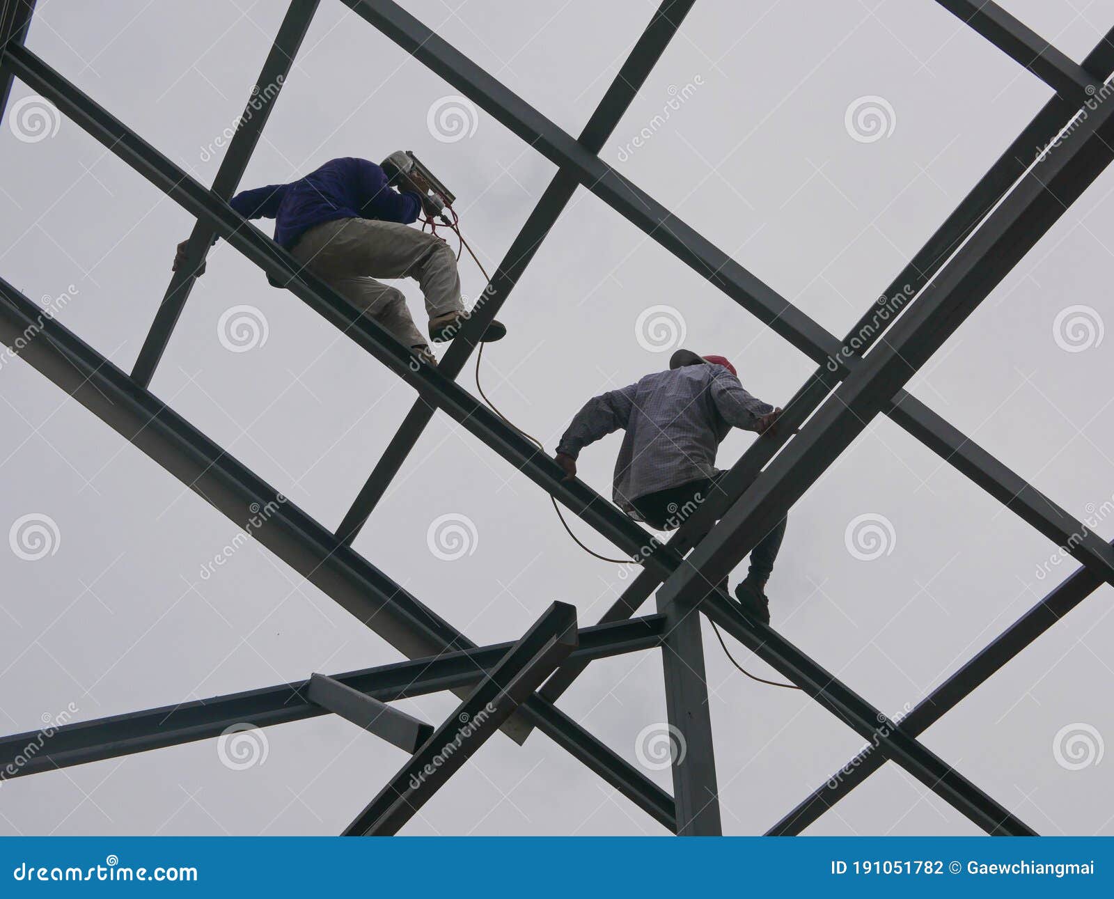 Two Structural Steel Workers Working on a High Rooftop for a House Roof ...