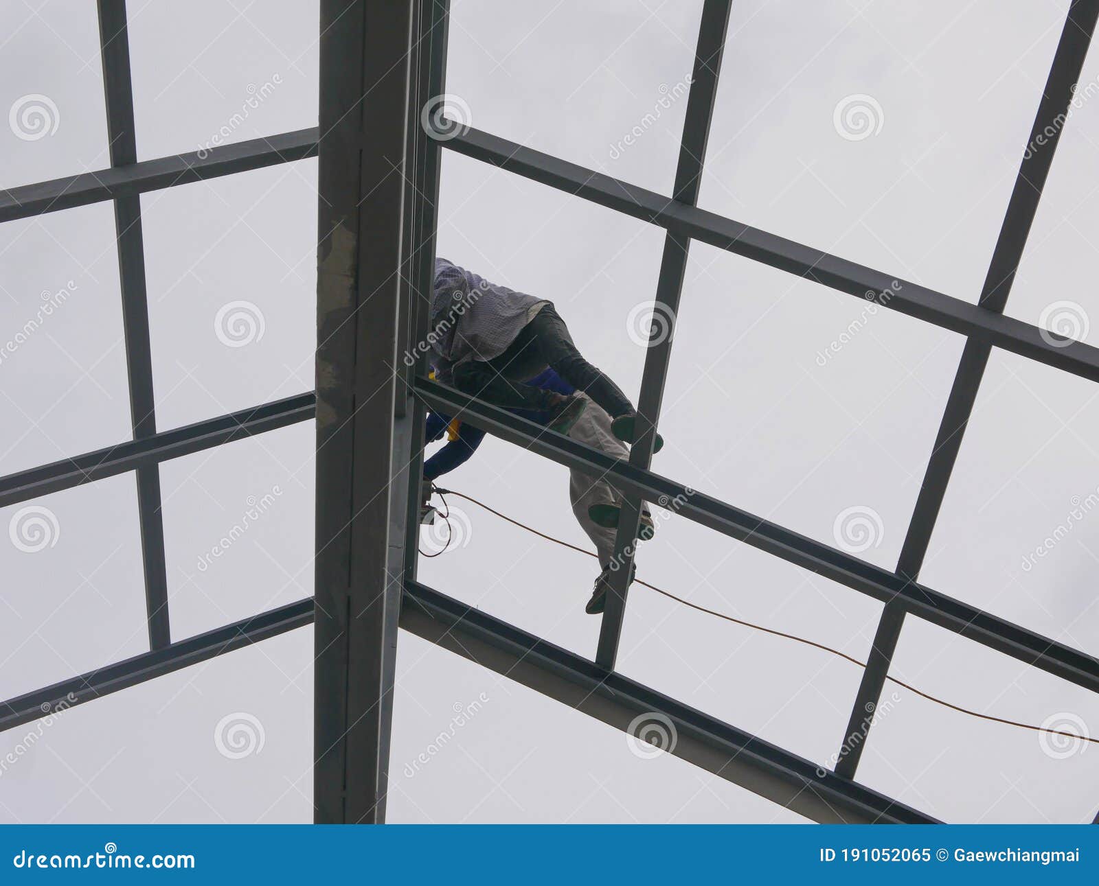 Two Structural Steel Workers Working on a High Rooftop for a House Roof ...
