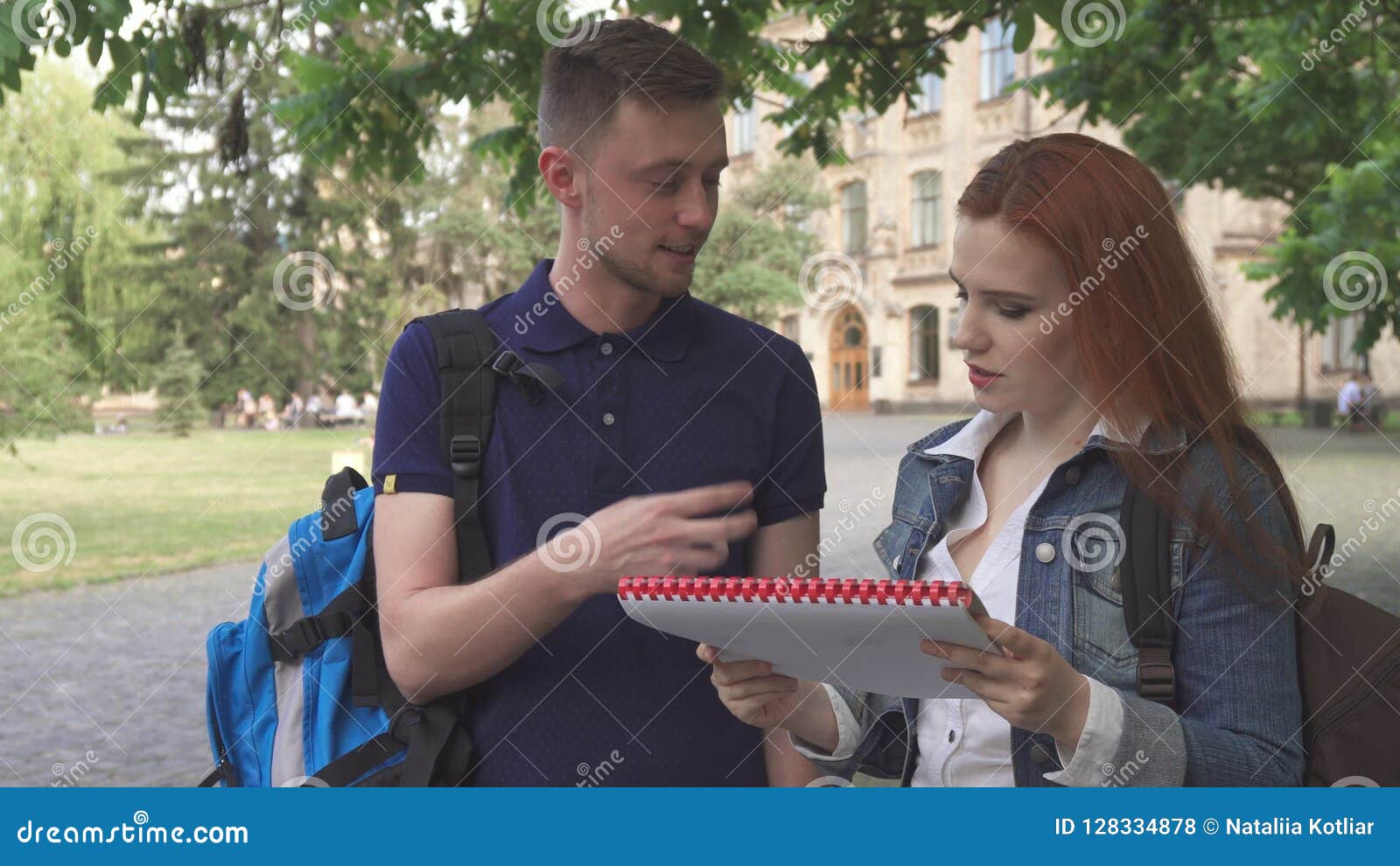 Two Students Discuss Something in Notebook on Campus Stock Photo ...
