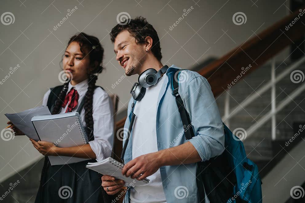 Two Students Discussing Notes in a School Hallway Setting Stock Photo ...