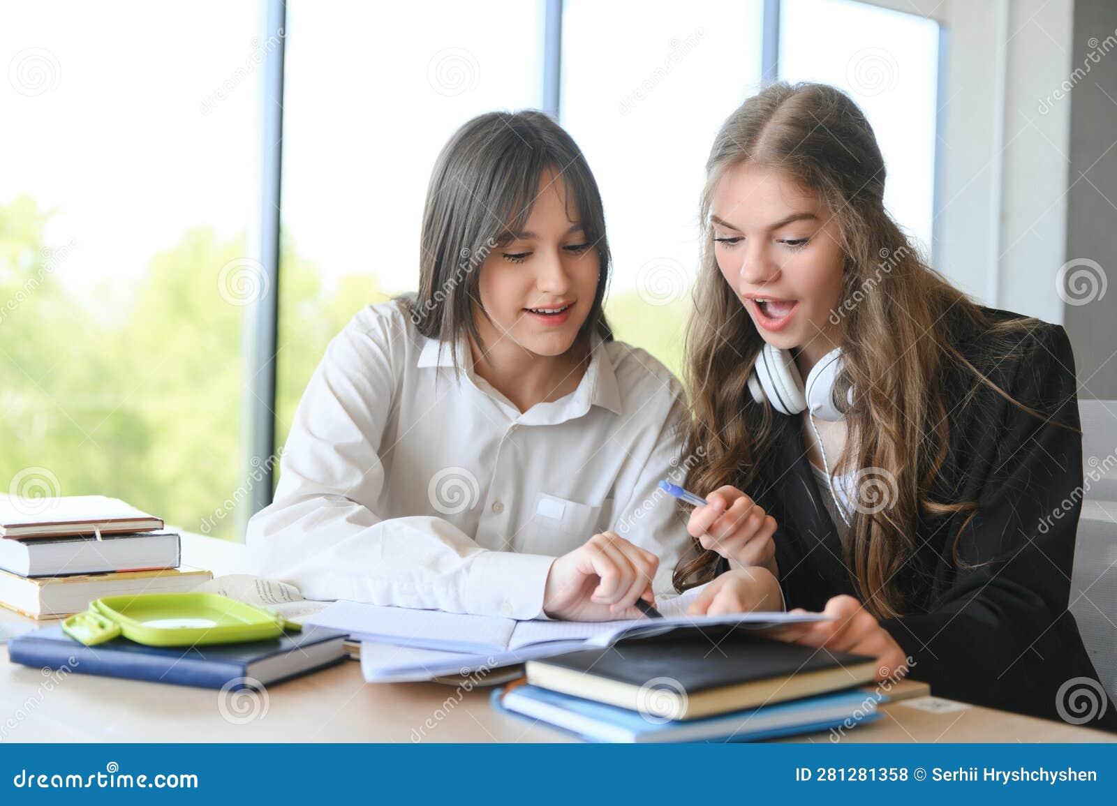 Two Students Doing Homework Together and Helping Each Other Sitting in ...