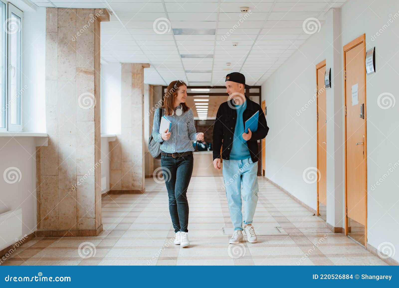 Two Students, a Guy and a Girl, are Walking Along the Corridor of the ...