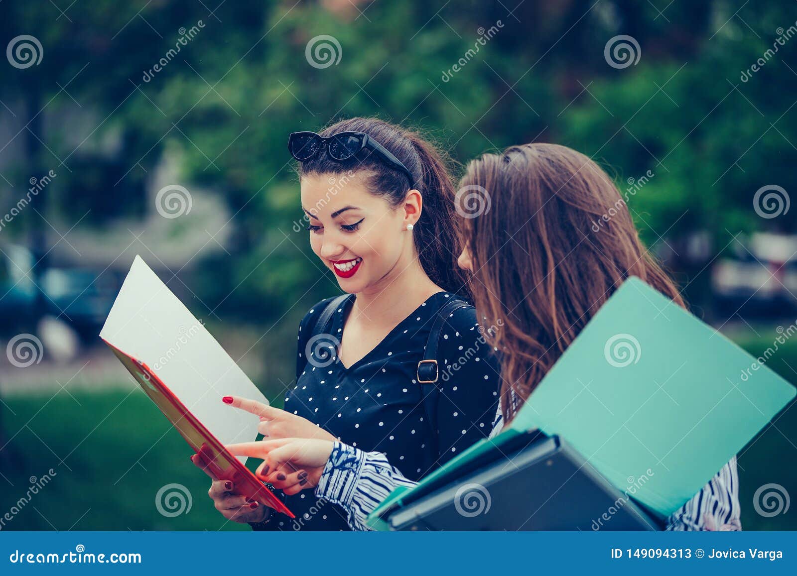 Two Students Learning Reading a Notebook and Commenting in the Street ...