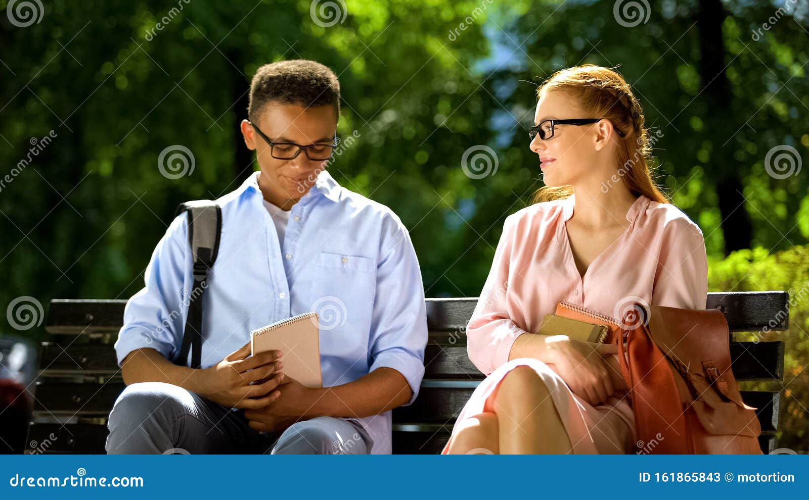 Two Students Making Acquaintance Sitting on Bench in Park, First ...
