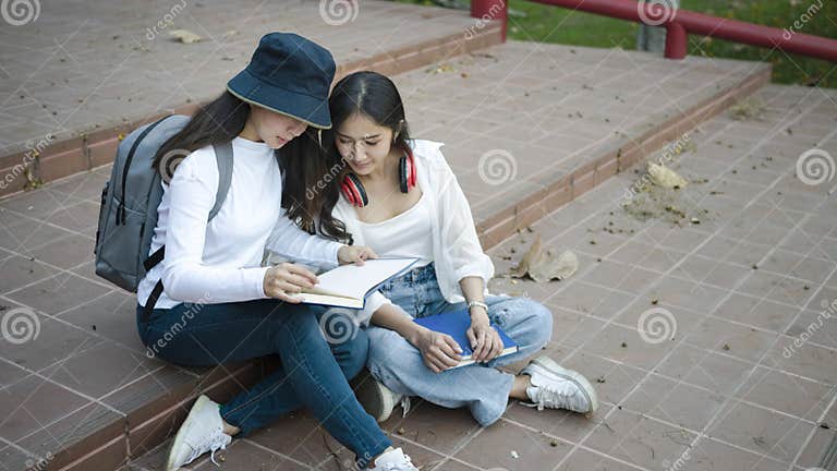 Two Students Sharing Notes while Sitting on Staircase in the University ...