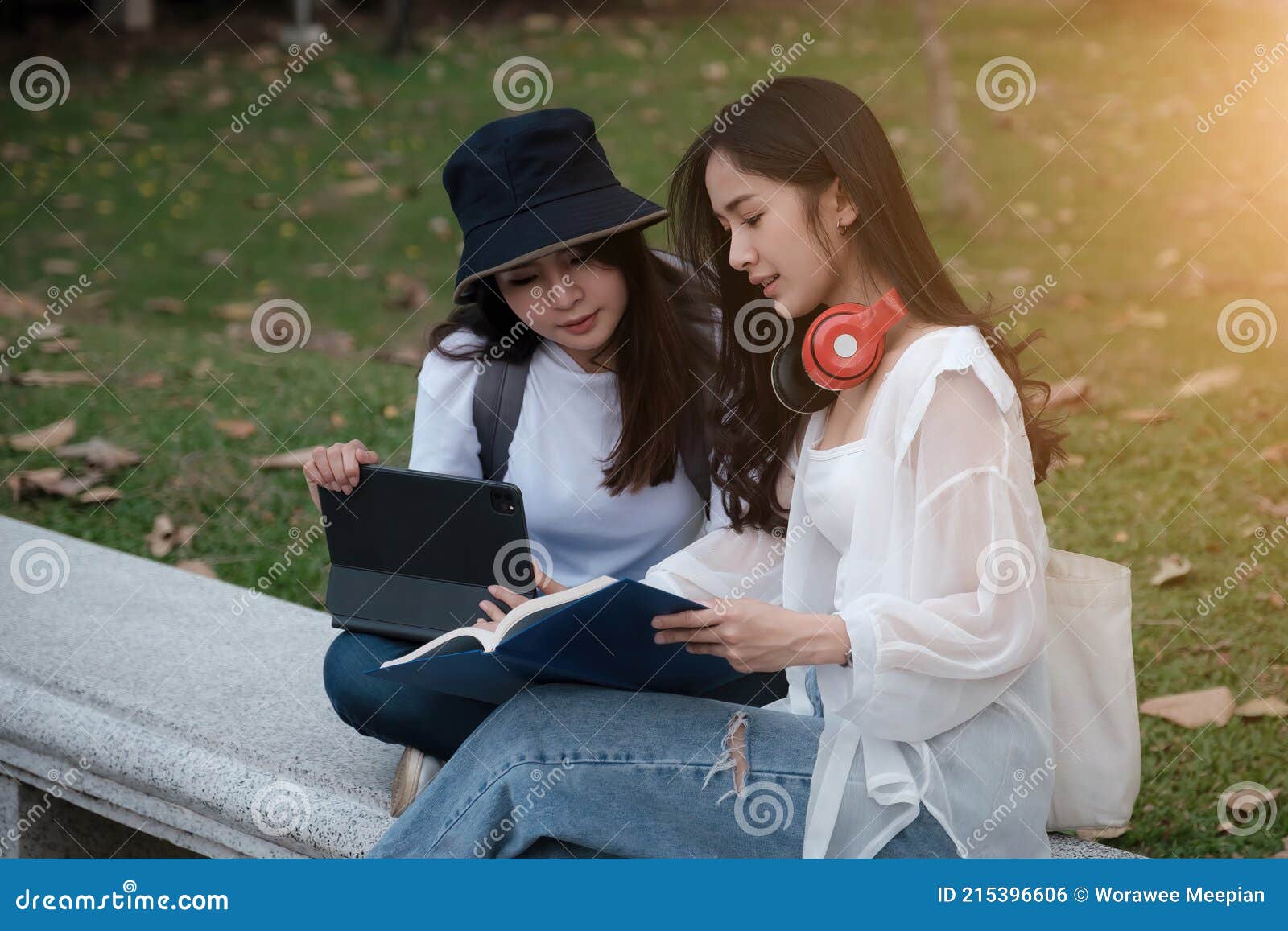 Two Students are Sitting in Park during Reading a Book and ...