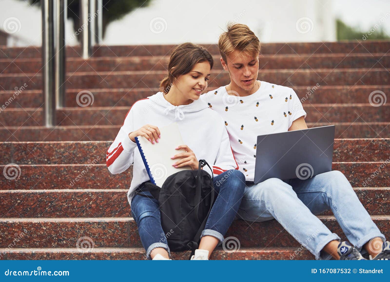 Two Students Sitting on Stairs Outdoors with Laptop at Daytime Stock ...