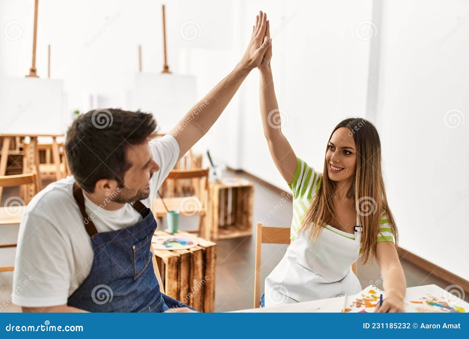 Two Students Smiling Happy High Five Sitting on the Table at Art School ...