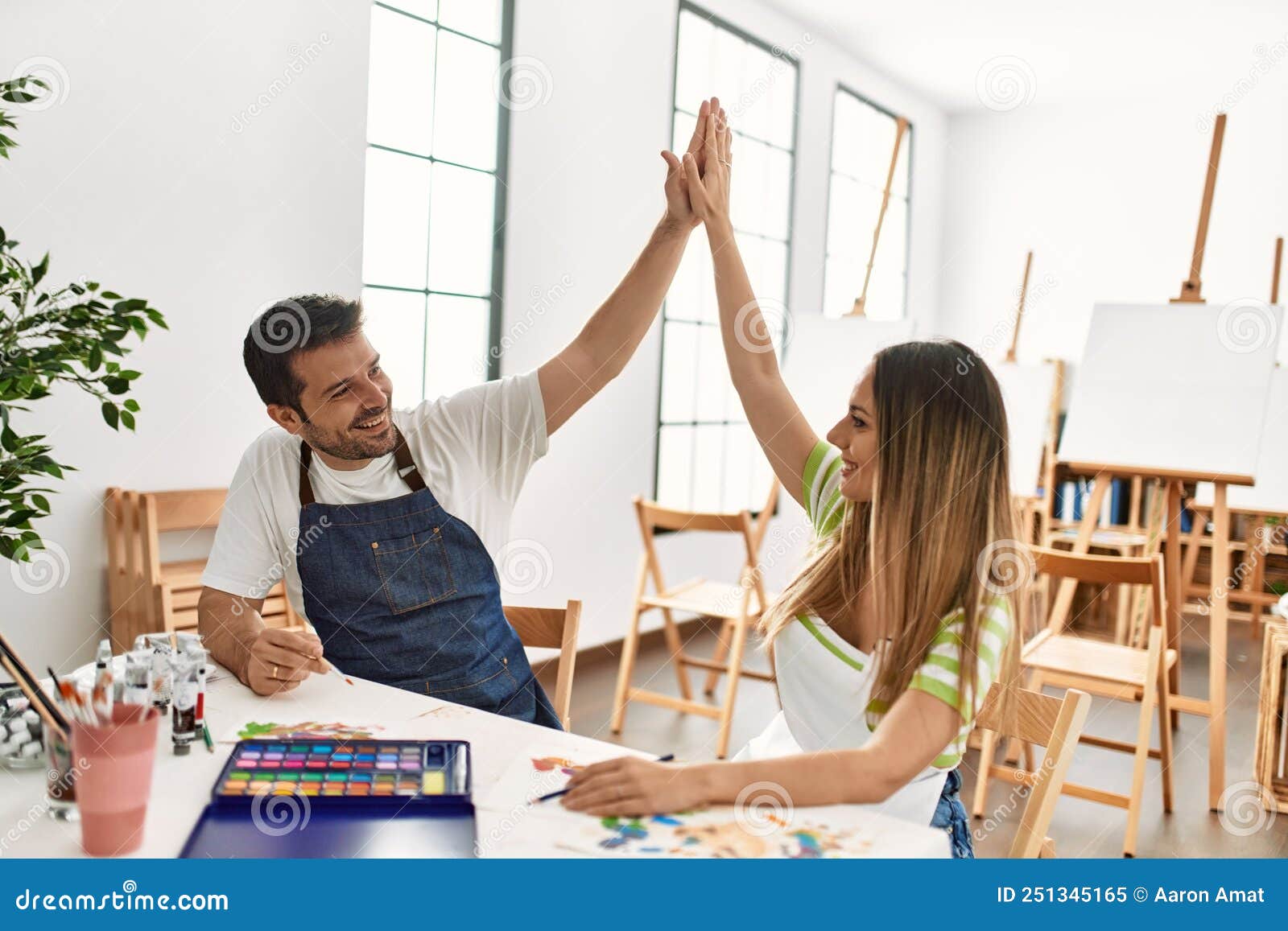 Two Students Smiling Happy High Five Sitting on the Table at Art School ...