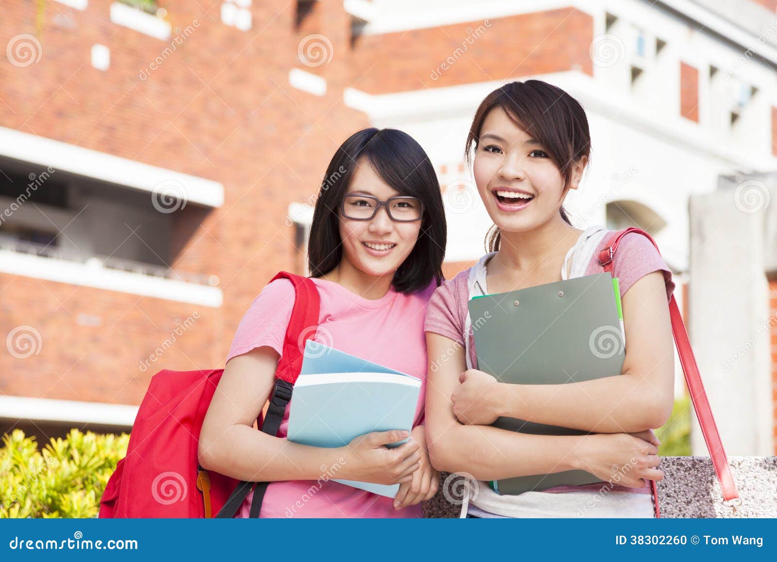 Two Students Smiling and Holding Books at Campus Stock Photo - Image of ...