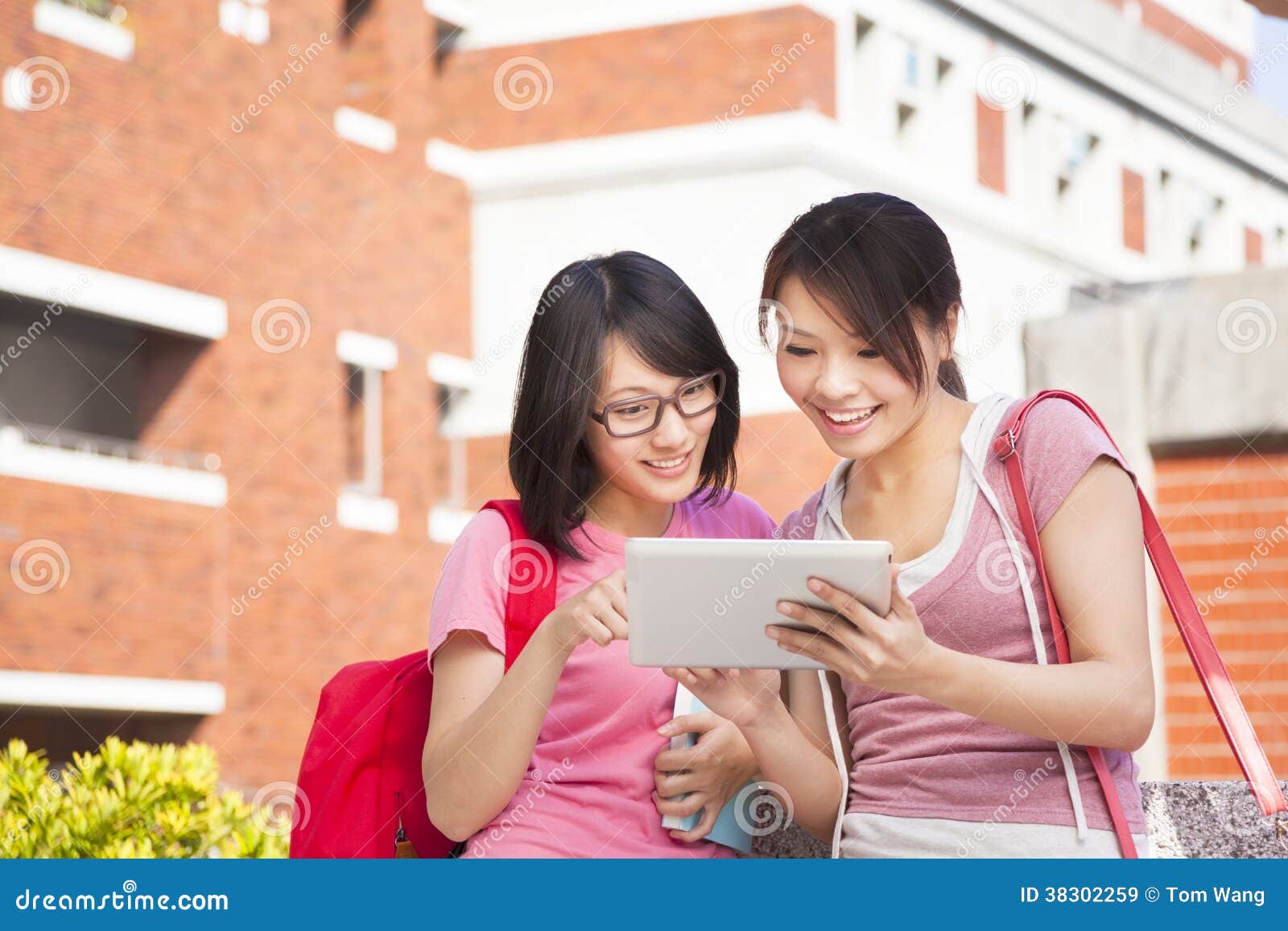 Two Students Using a Tablet To Discuss Homework Stock Image - Image of ...