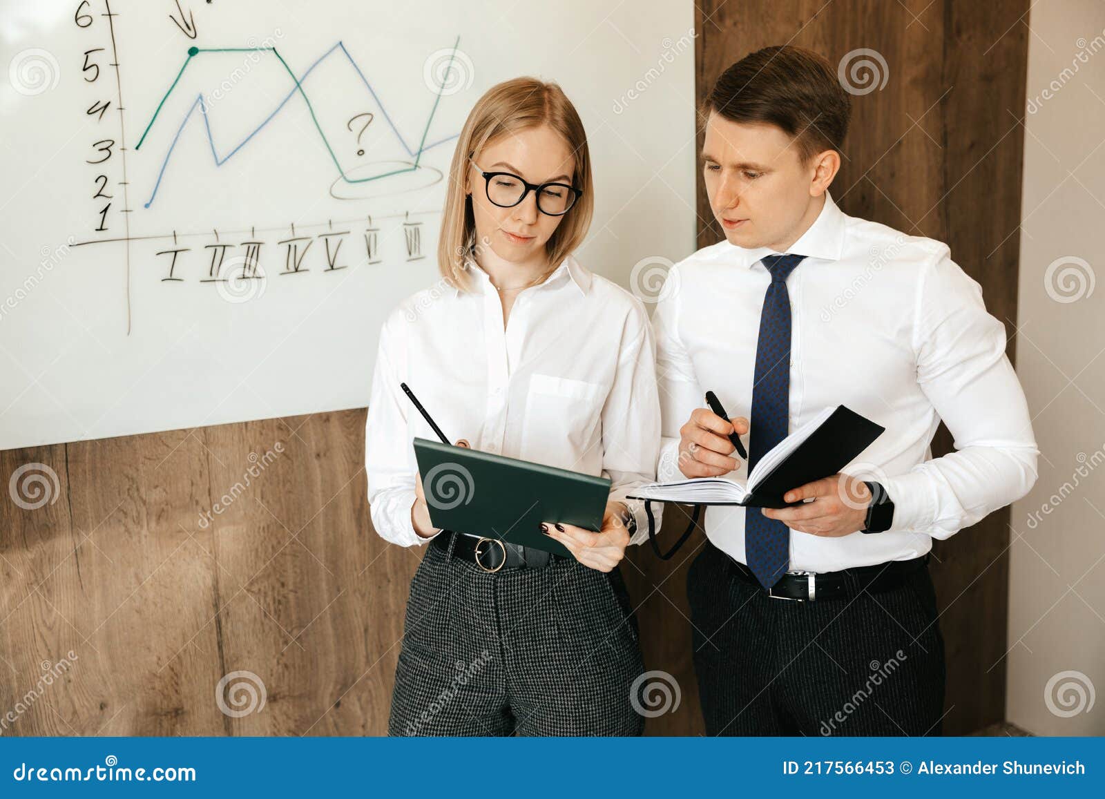 Two Successful Businessmen Fill Out Documents in the Office. Discuss ...