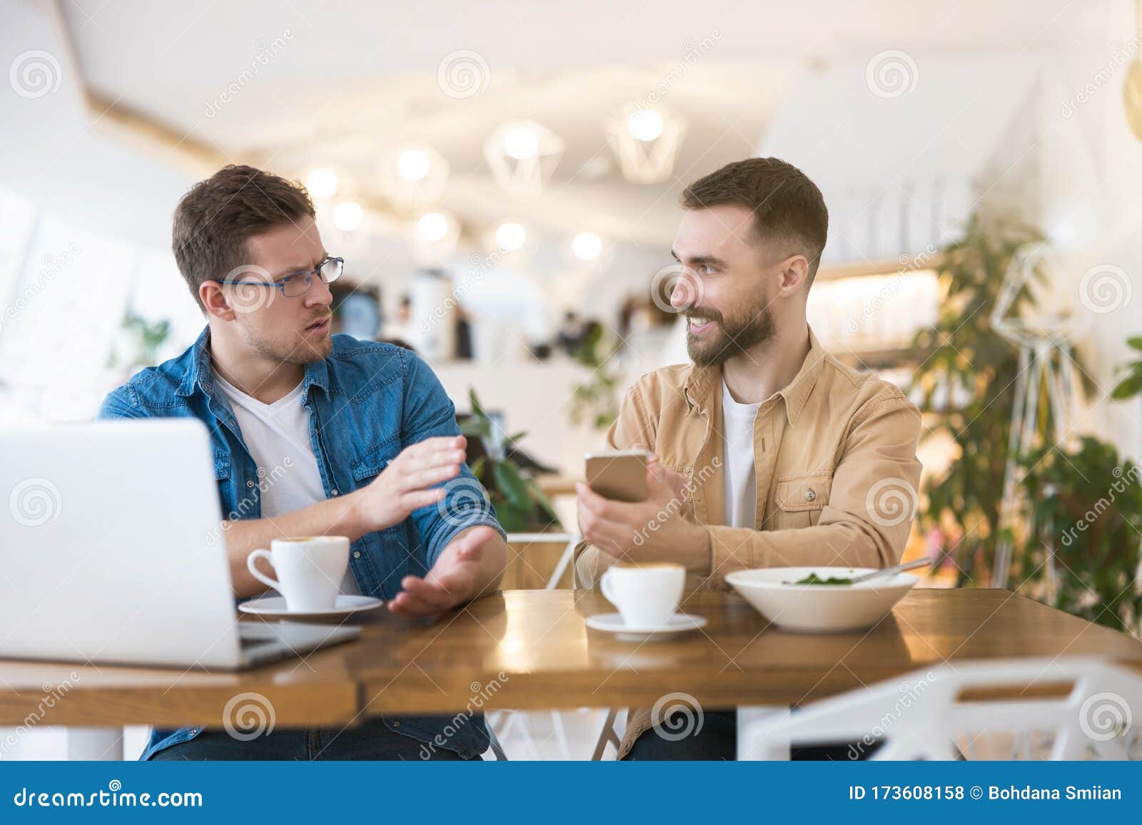 Two Successful Colleagues Men Solving Work Issues during Coffee Break ...