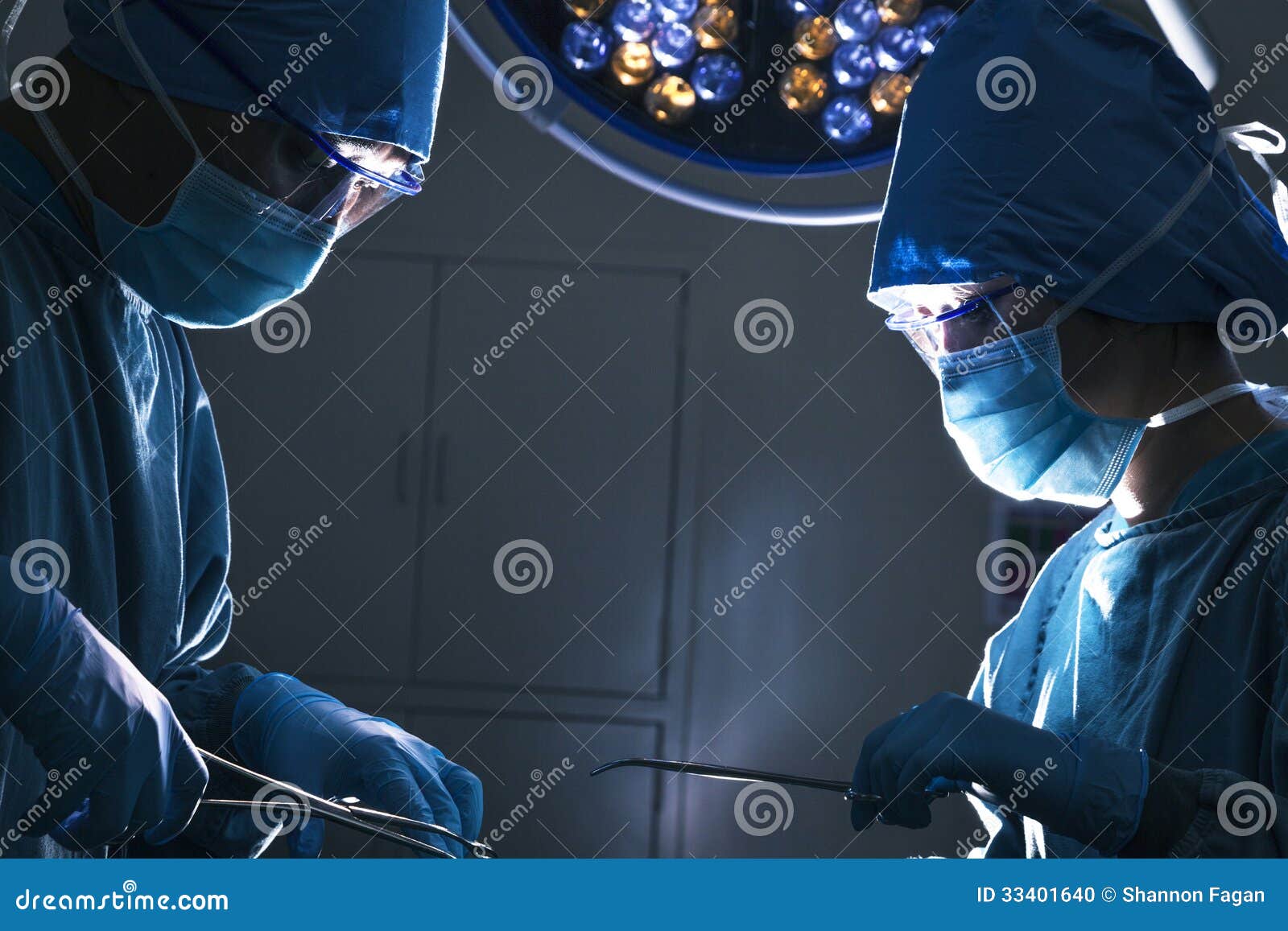 Two Surgeons Looking Down and Working at the Operating Table, Dark ...