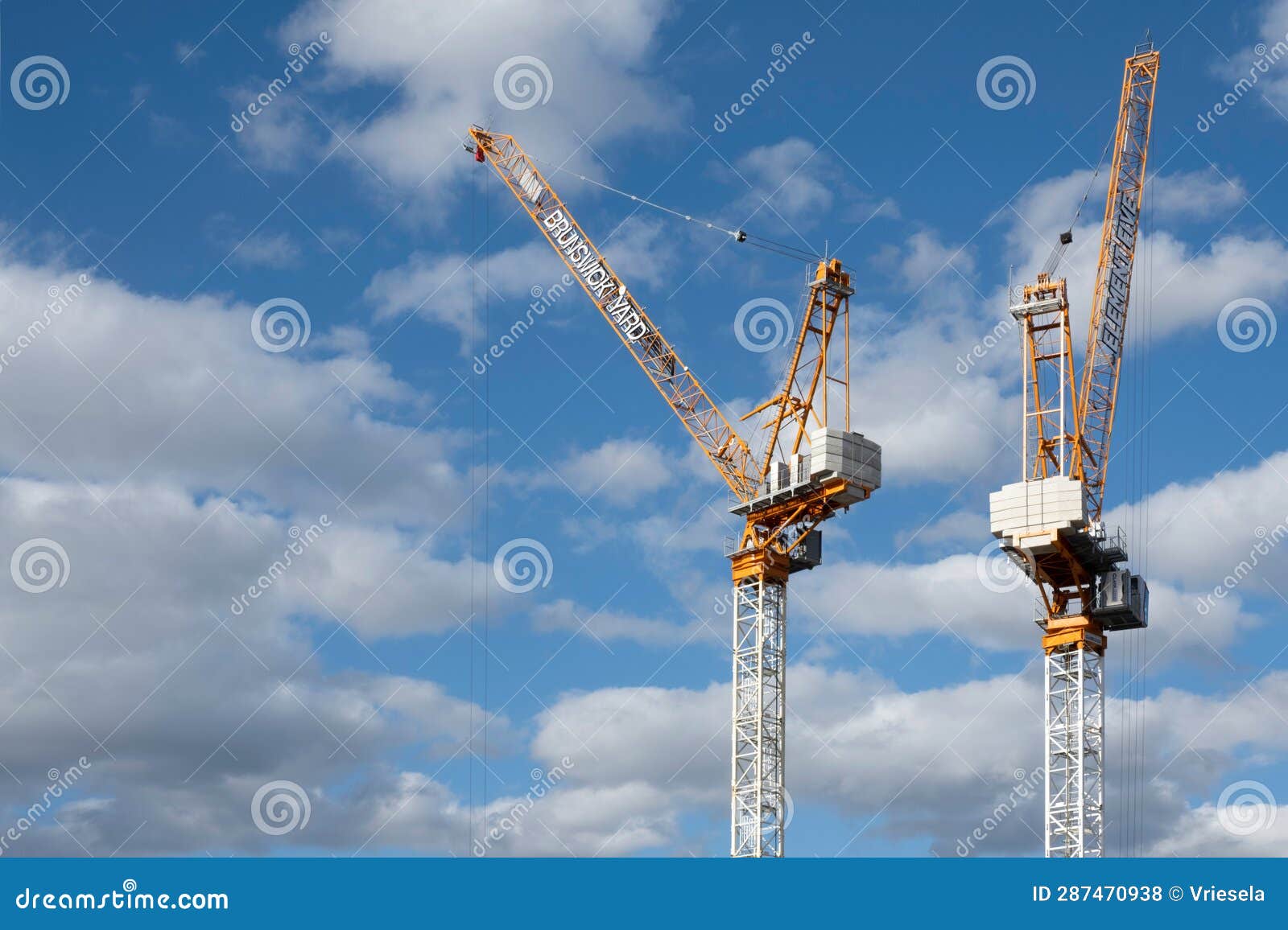 Two Tall Cranes with Cabin in Which the Operator Controls the Crane on ...