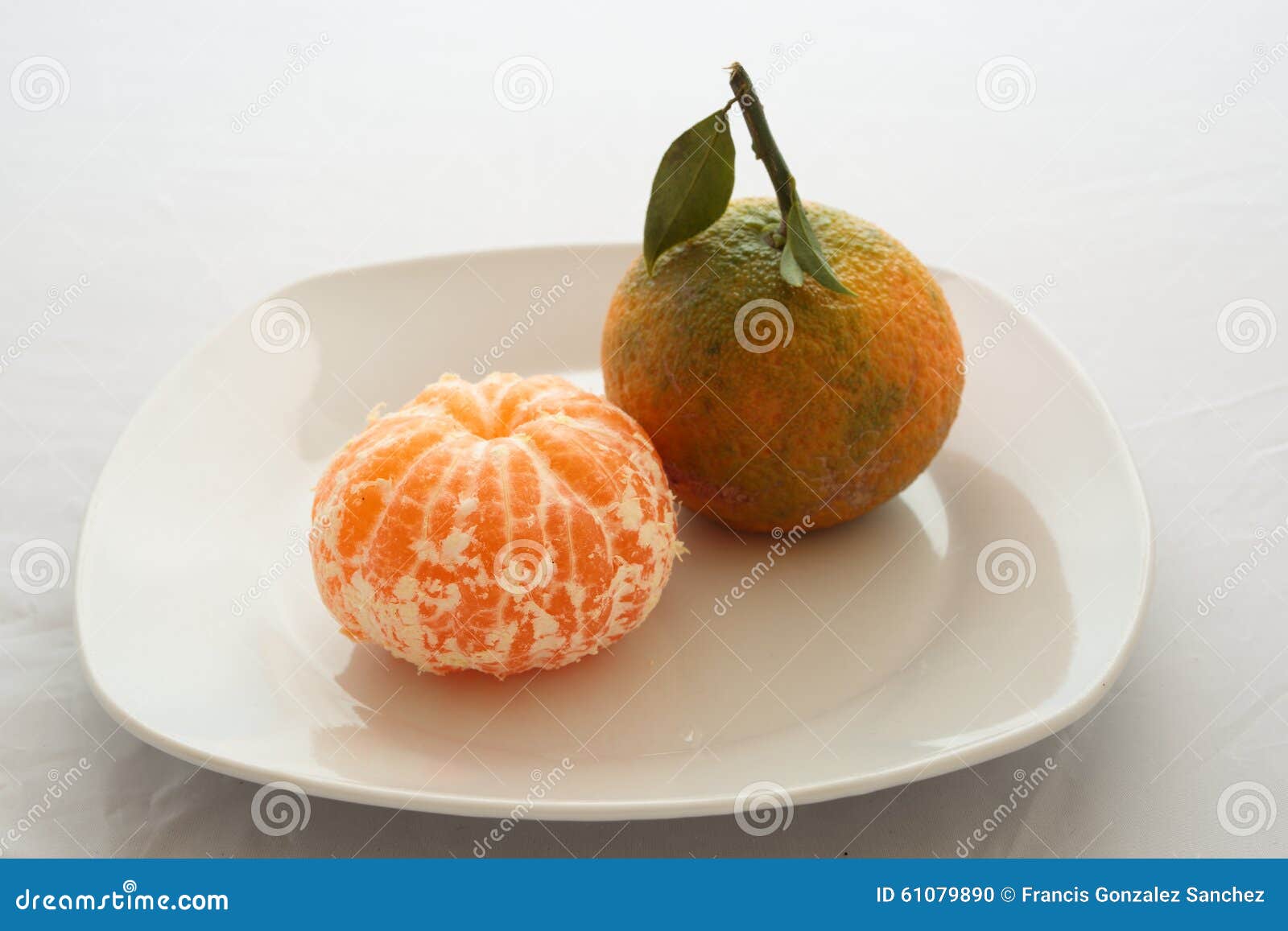 Two tangerines on a plate stock photo. Image of white - 61079890