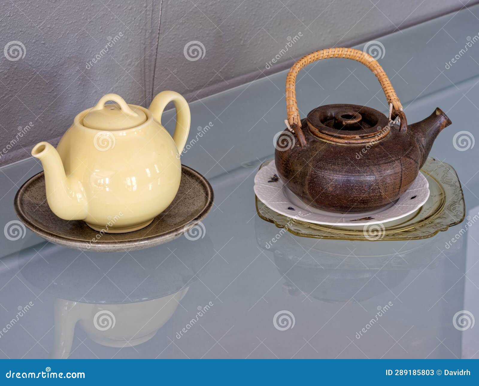 Two Teapots in Saucers on a Glass Table Stock Image - Image of room ...