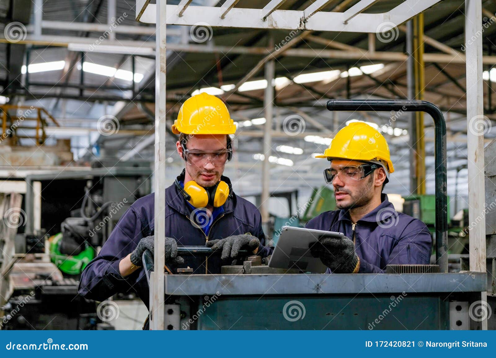 Two Technician Men with Blue Uniform and Yellow Helmet Work with the ...