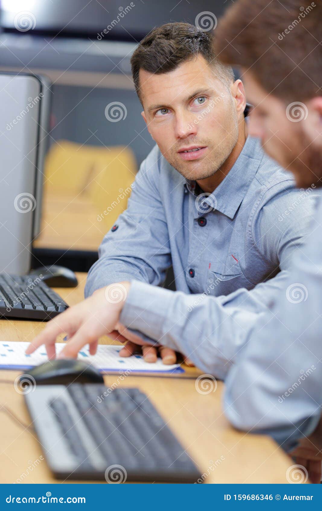 Two Technicians in Discussion Sat at Computer Desk Stock Photo - Image ...