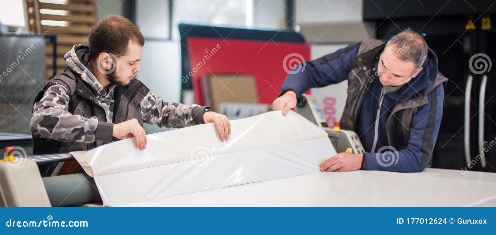 Two Technicians Glue Poster To Foam. Semi Automatic Gluing Machine ... Two Technicians Glue Poster To Foam. Semi Automatic Gluing Machine ...