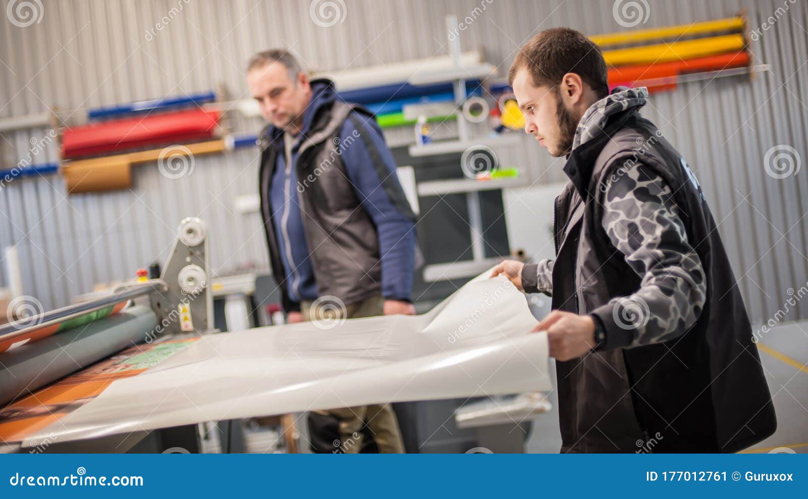 Two Technicians Glue Poster To Foam. Semi Automatic Gluing Machine ... Two Technicians Glue Poster To Foam. Semi Automatic Gluing Machine ...