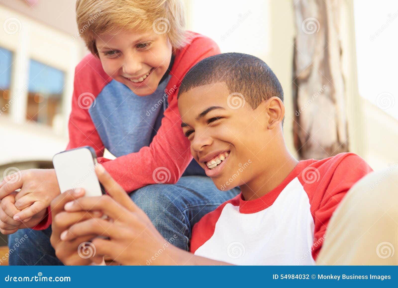 Two Teenage Boys Reading Text on Mobile Phone Stock Photo - Image of ...