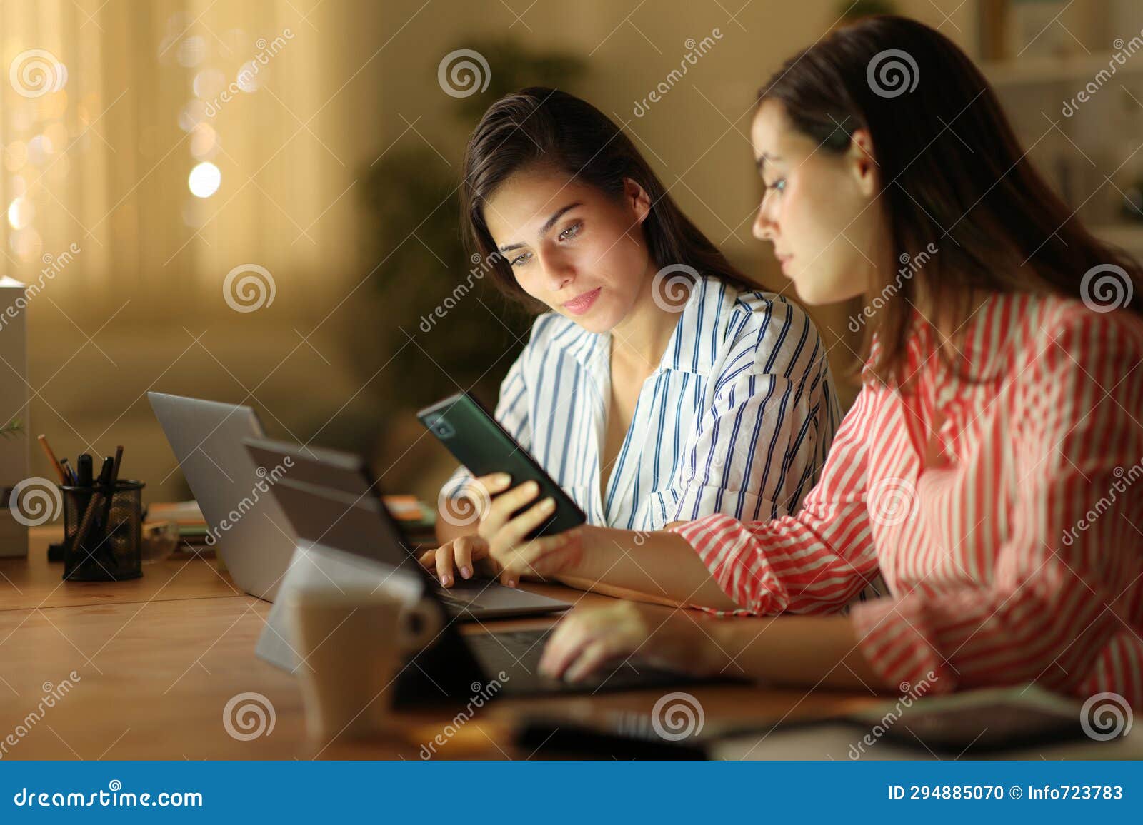 Two Tele Workers Using Multiple Devices in the Night at Home Stock ...