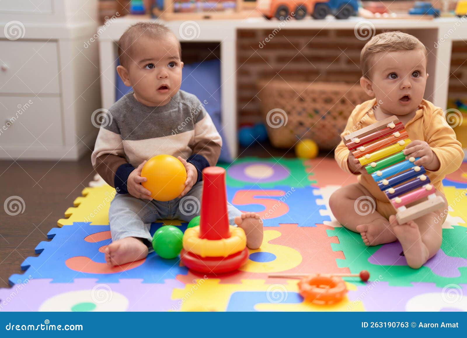 Two Toddlers Playing with Ball and Xylophone at Kindergarten Stock ...