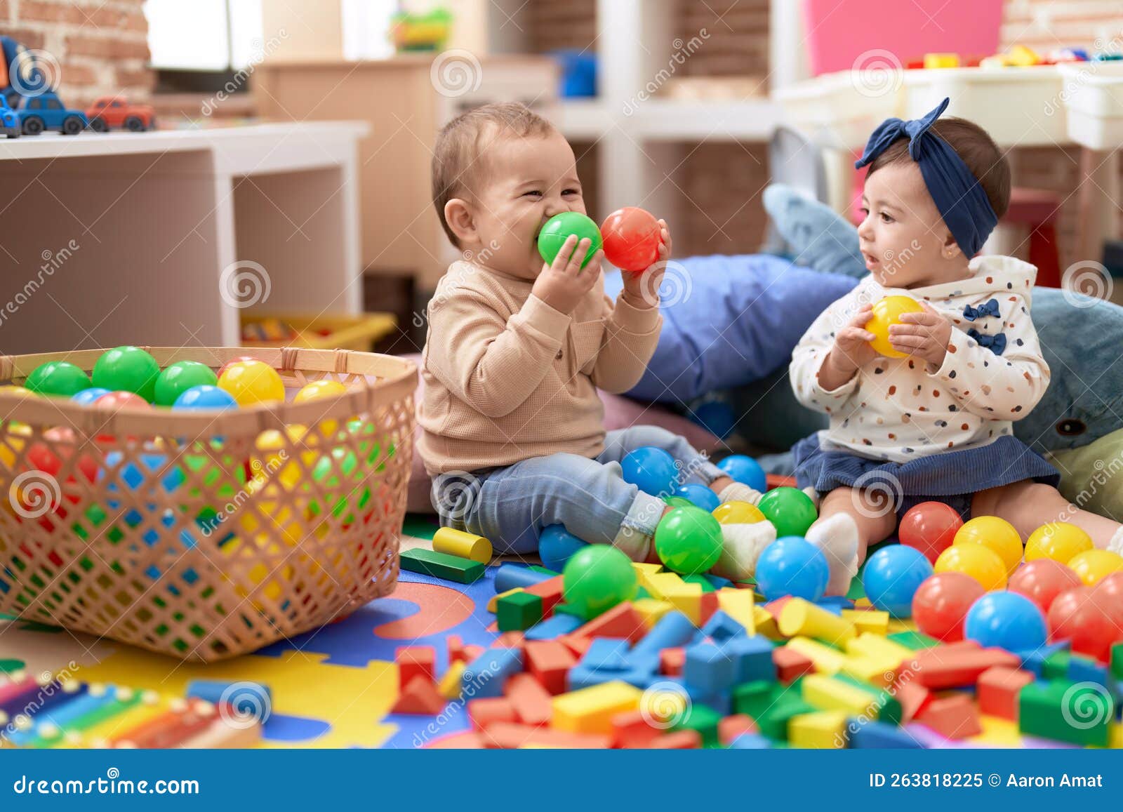 Two Toddlers Playing with Balls Sitting on Floor at Kindergarten Stock ...