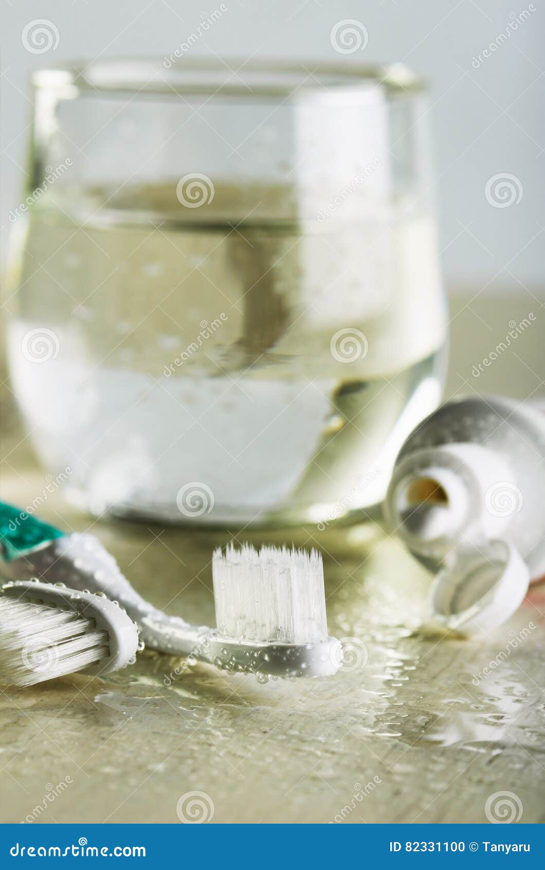 Two Toothbrushes, Toothpaste and a Glass of Water on a Wet Table Stock ...