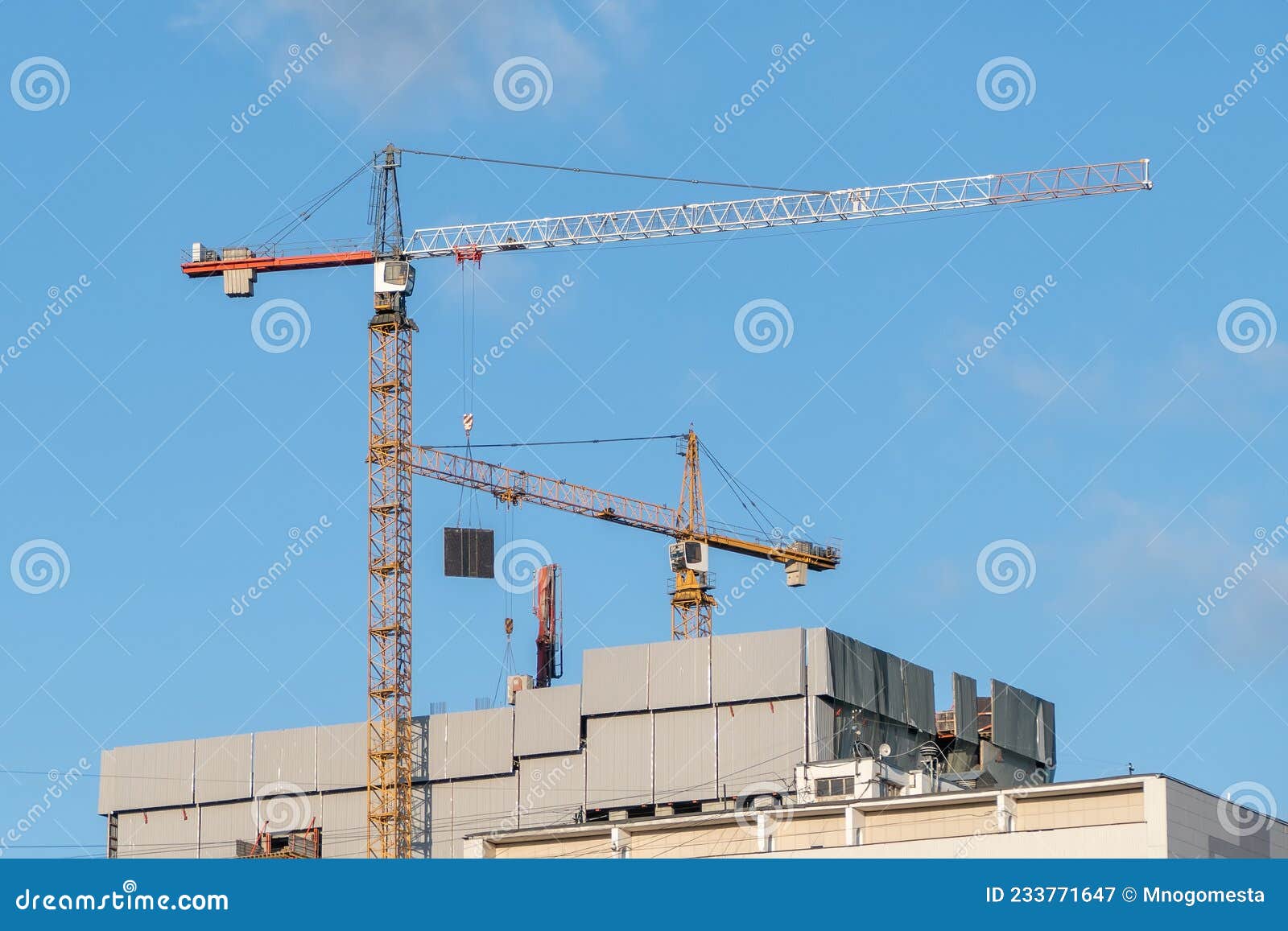 Two Tower Cranes on the Construction of a High-rise Building. Lifting ...