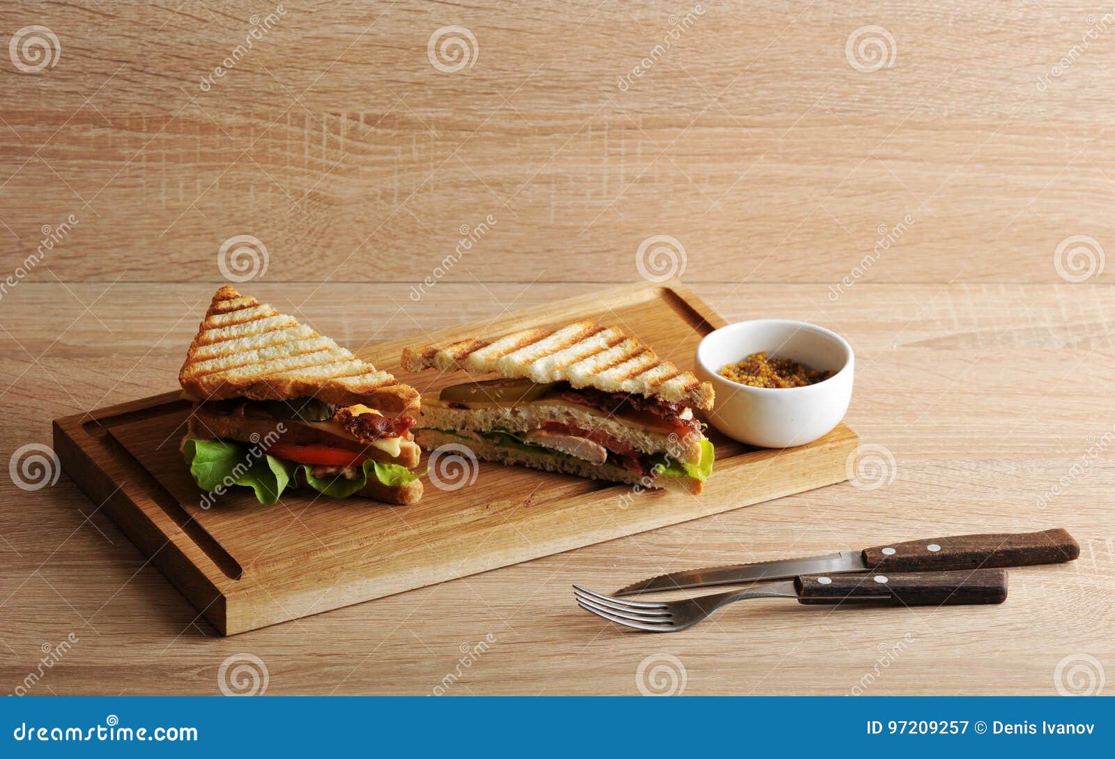 Two Triangular Sandwich with Bacon and Chicken Breast on a Wooden Board ...