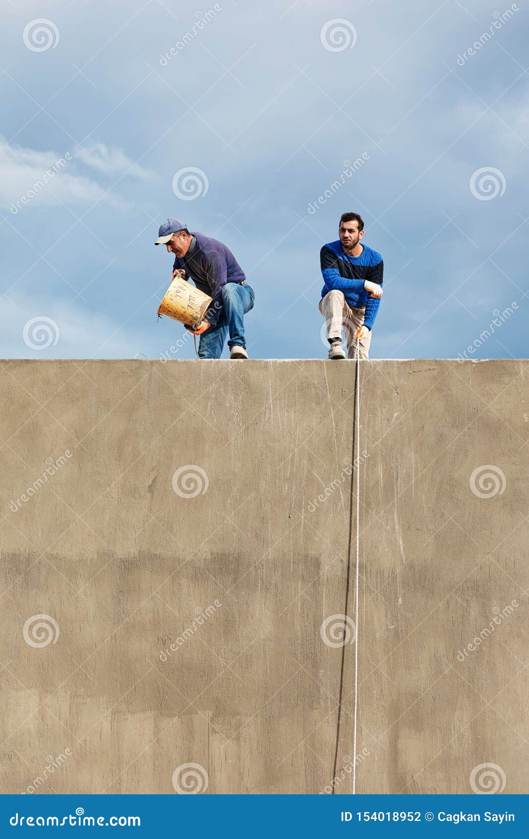 Two Turkish Construction Workers Working At The Top Of A Building And ...