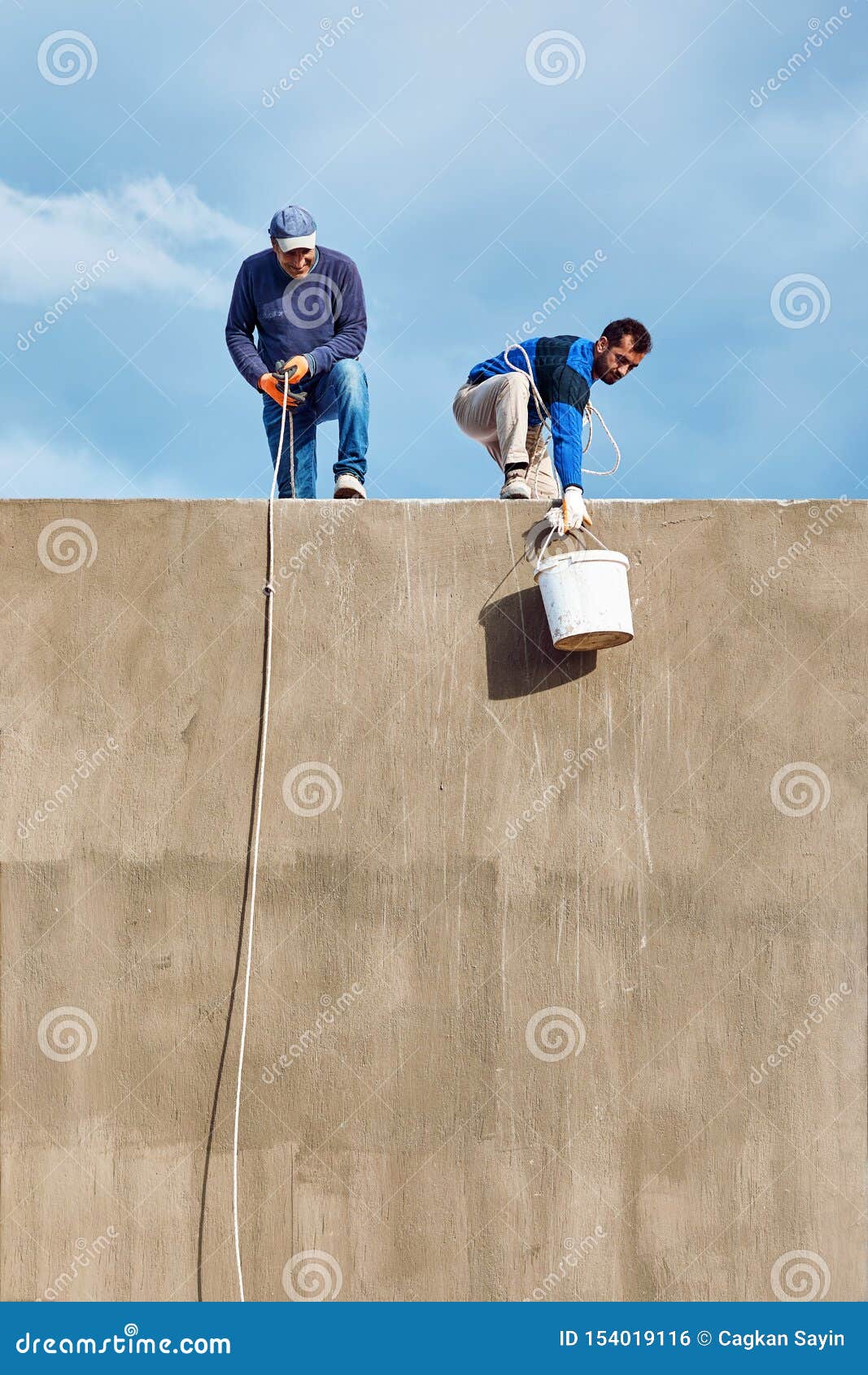 Two Turkish Construction Workers Working at the Top of a Building and ...