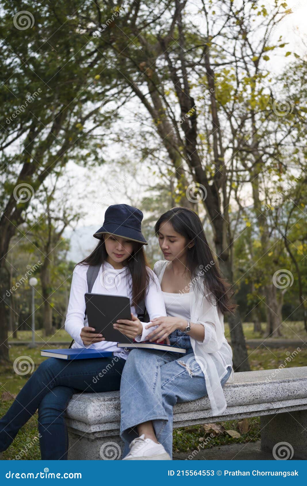 Two University Students Sitting on Bench in the Park and Talking after ...