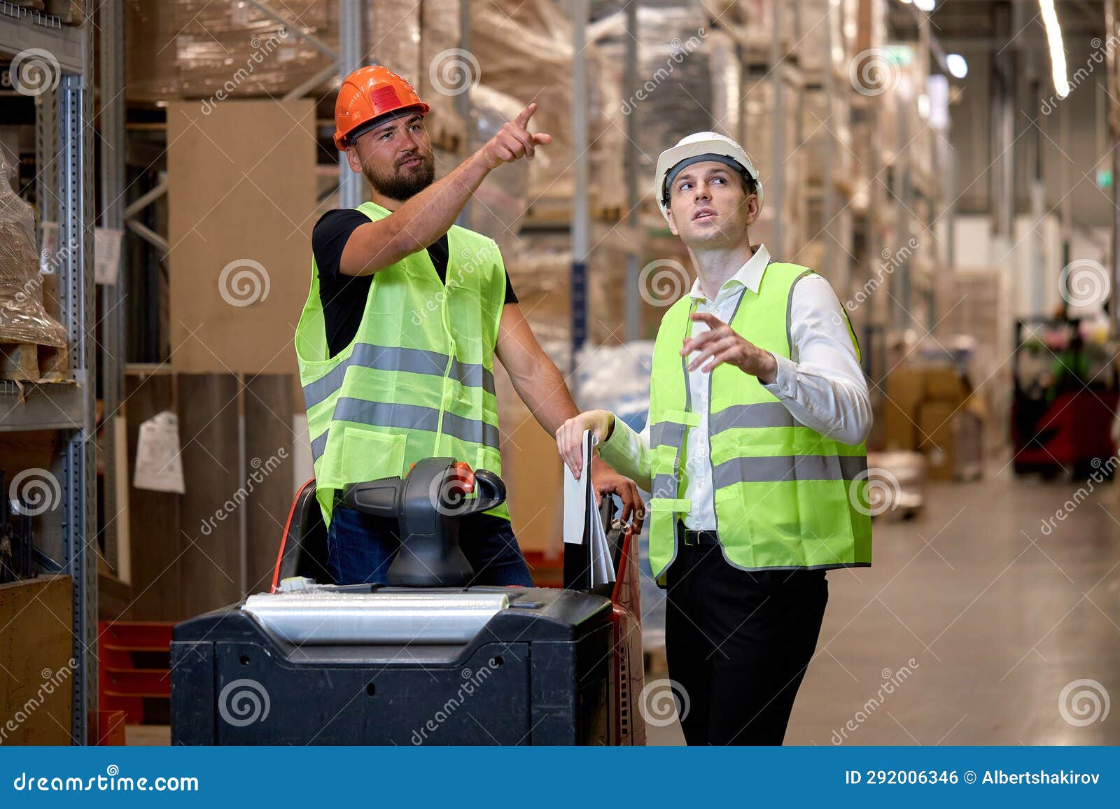 Two Warehouse Workers Men in Reflective Jackets Pulling a Pallet Truck ...