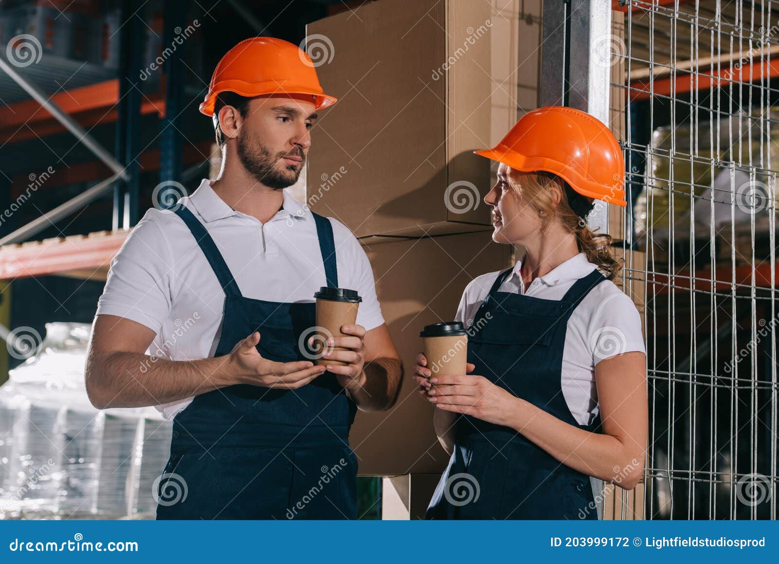 Two Warehouse Workers Talking while Holding Stock Photo - Image of ...