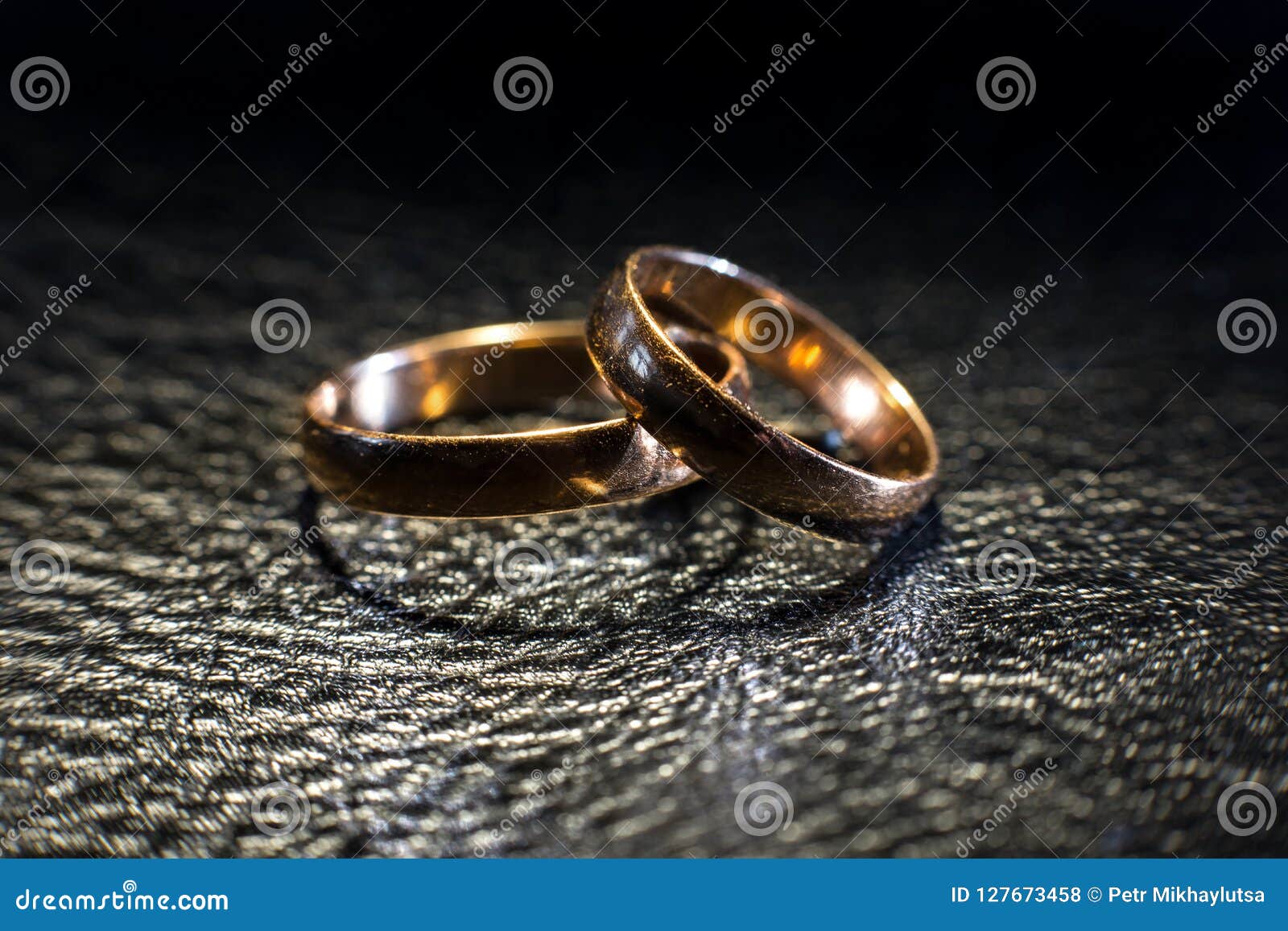 Two Wedding Rings of Different Sizes Made in Gold on the Black Leather ...
