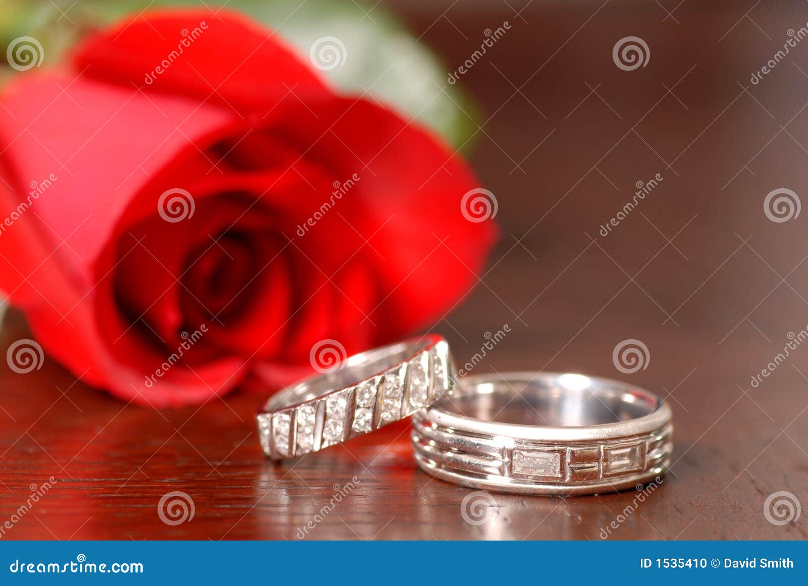 Two Wedding Rings with a Red Rose on a Table Stock Photo - Image of ...
