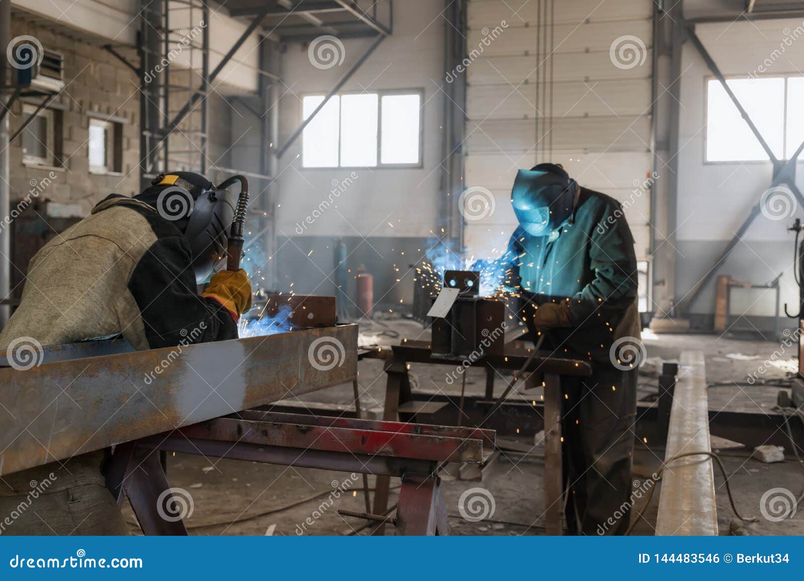Two Welders are Welding Metal Structures Mechanized Semi-automatic ...