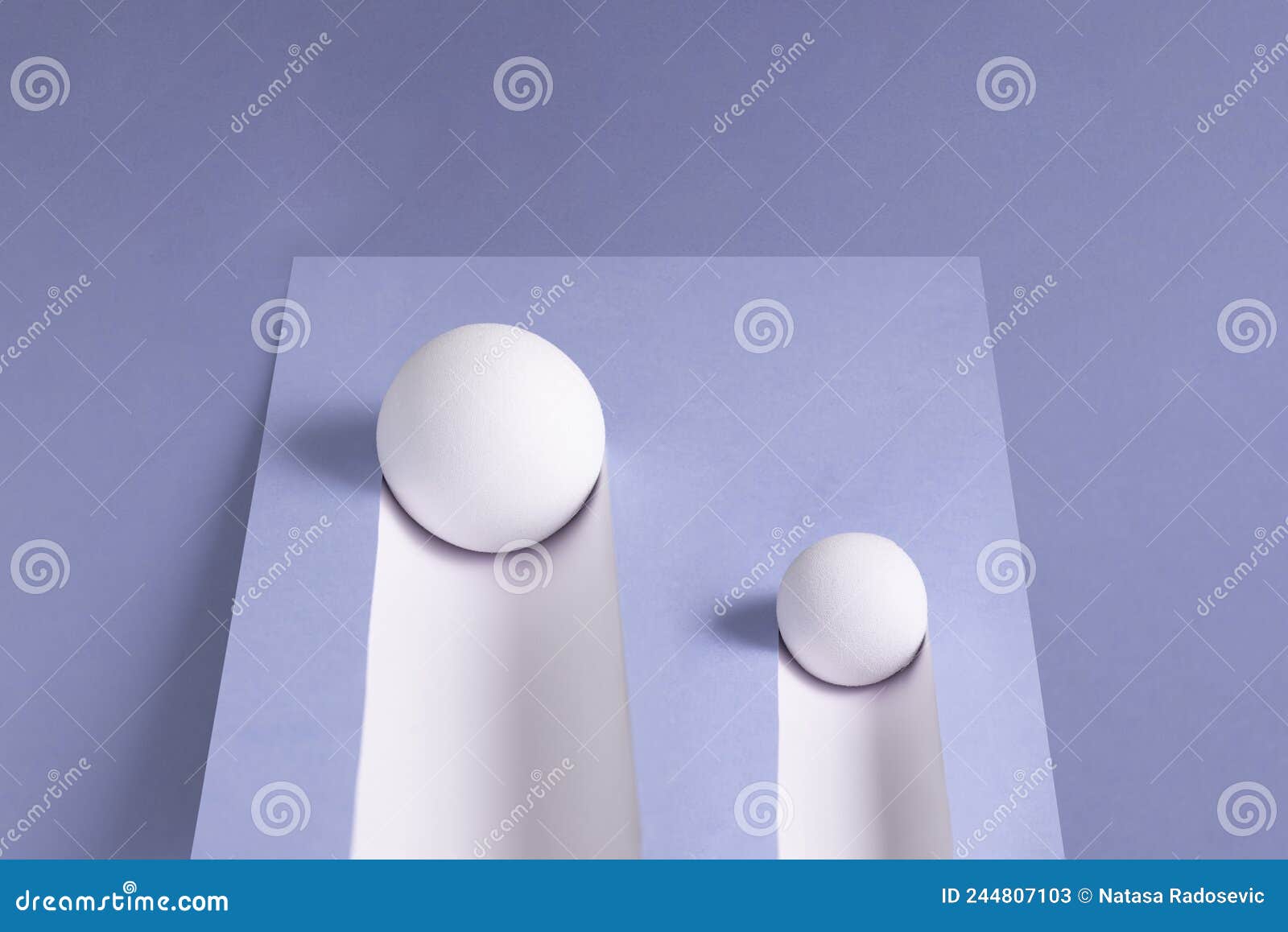 Two White Balls Roll Downhill and Leave a Trail on a Purple Background ...