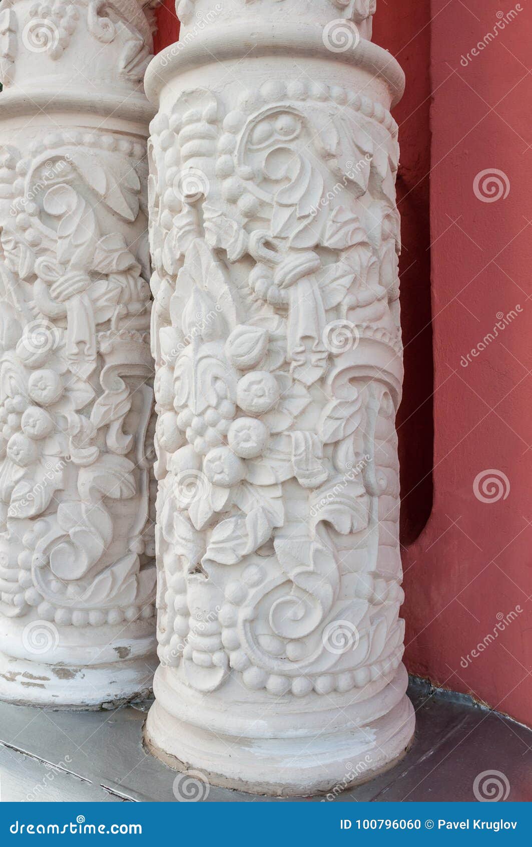 Two White Columns with Bas-reliefs Against a Red Wall Stock Photo ...