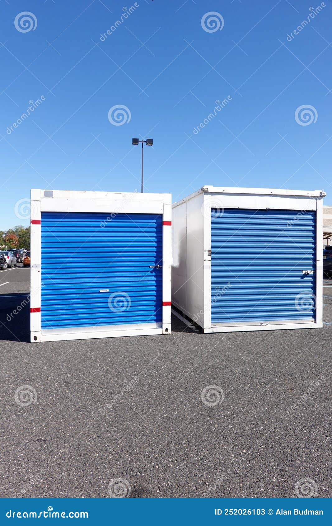 Two White Storage Pod Containers with a Blue Door on a Asphalt Road ...
