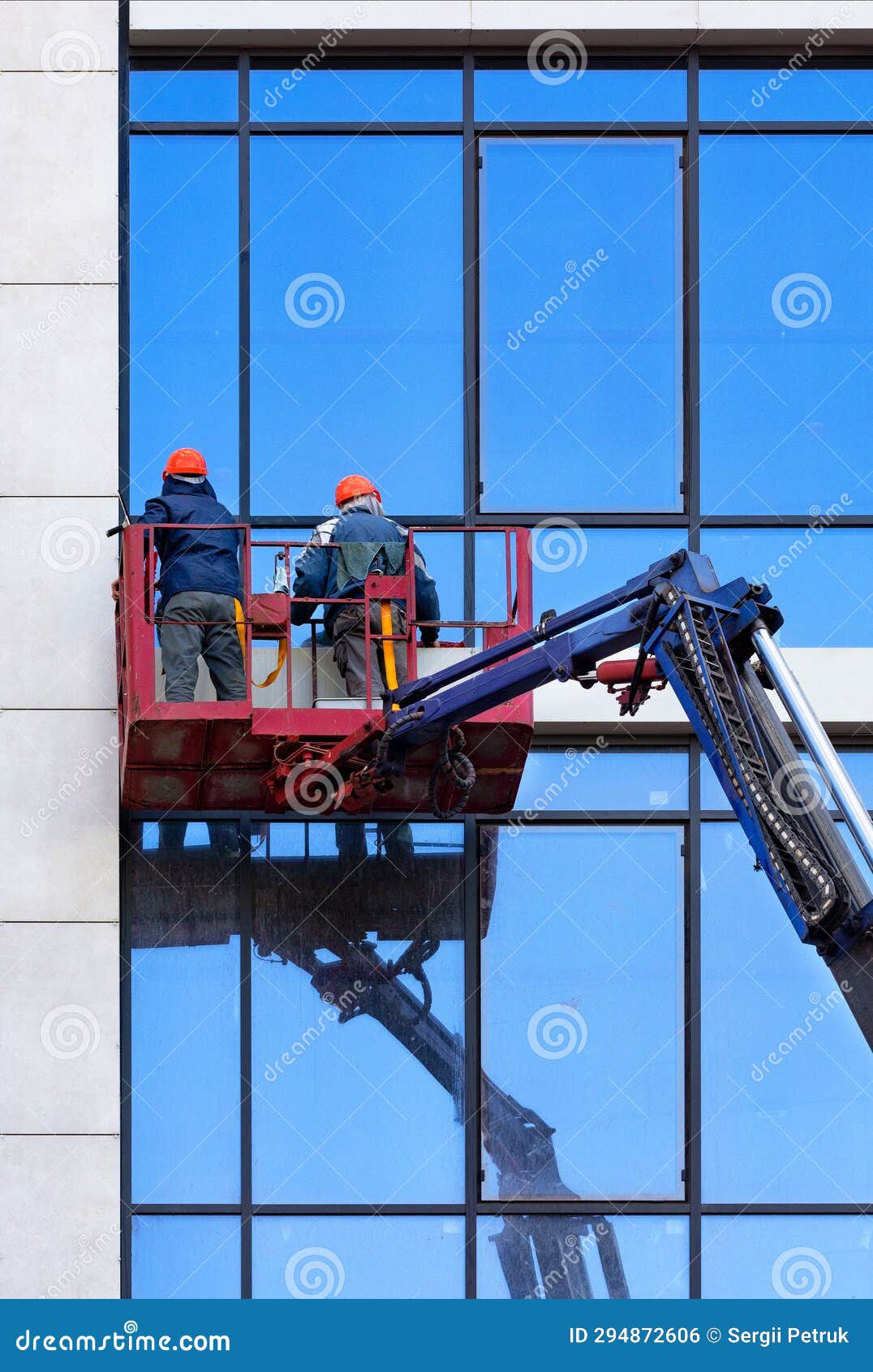 Two Men Cleaning Windows of an Exterior Glass Facade on a Construction ...