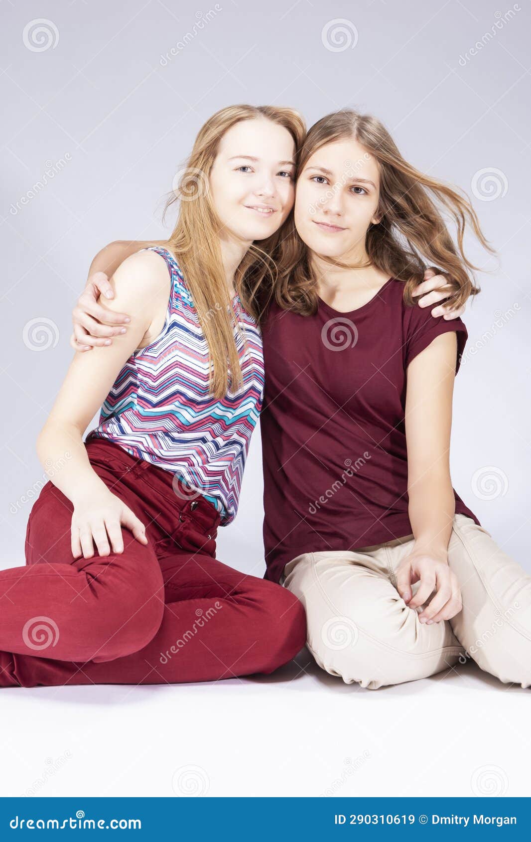 Two Winsome Caucasian Girlfriends Together While Sitting Embraced Over